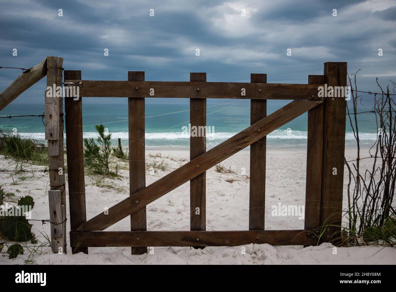 Closed gate to a sea on the sandy beach Stock Photo - Alamy