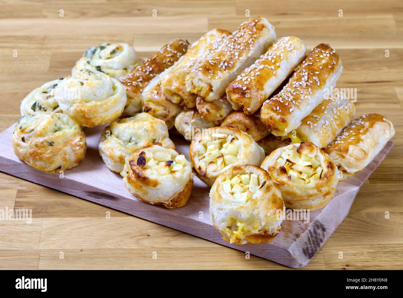 Pies and buns on a wooden table. Fresh pastries are prepared at home. A ...