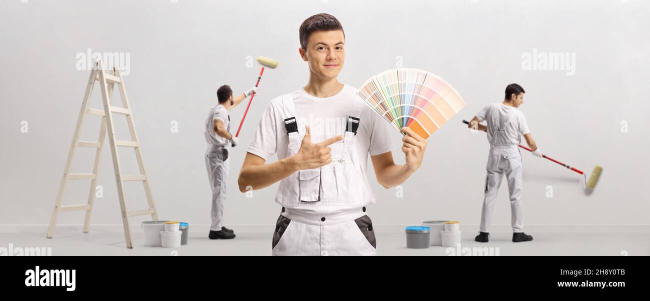 Young worker from a painting company holding a color swatch palette and ...
