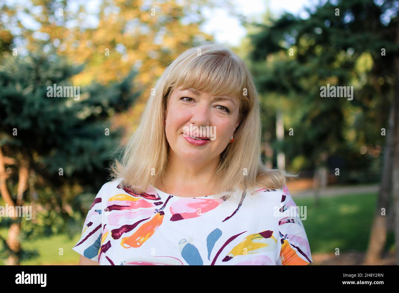 Plus size young woman in dress at nature in the park during summer ...