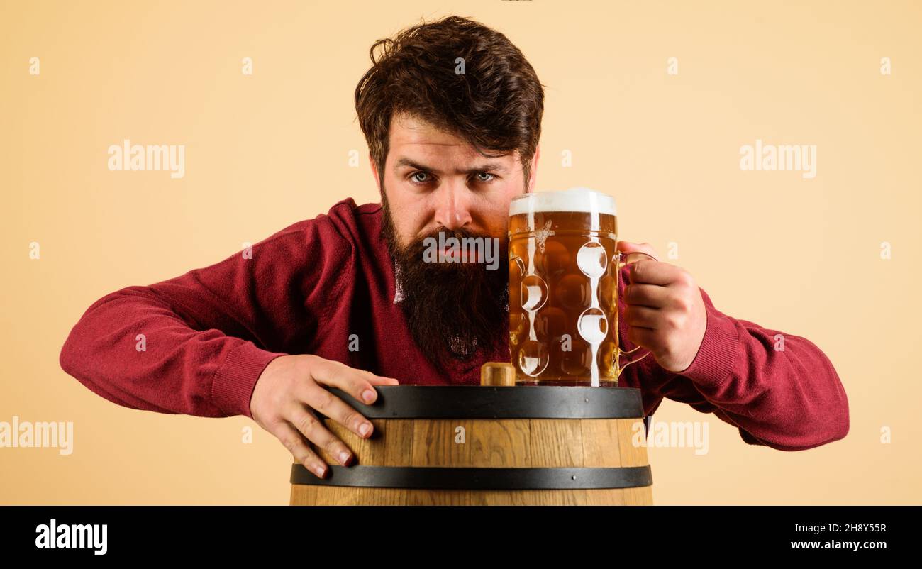 Serious bearded man with beer. Handsome male tastes fresh brewed beer ...