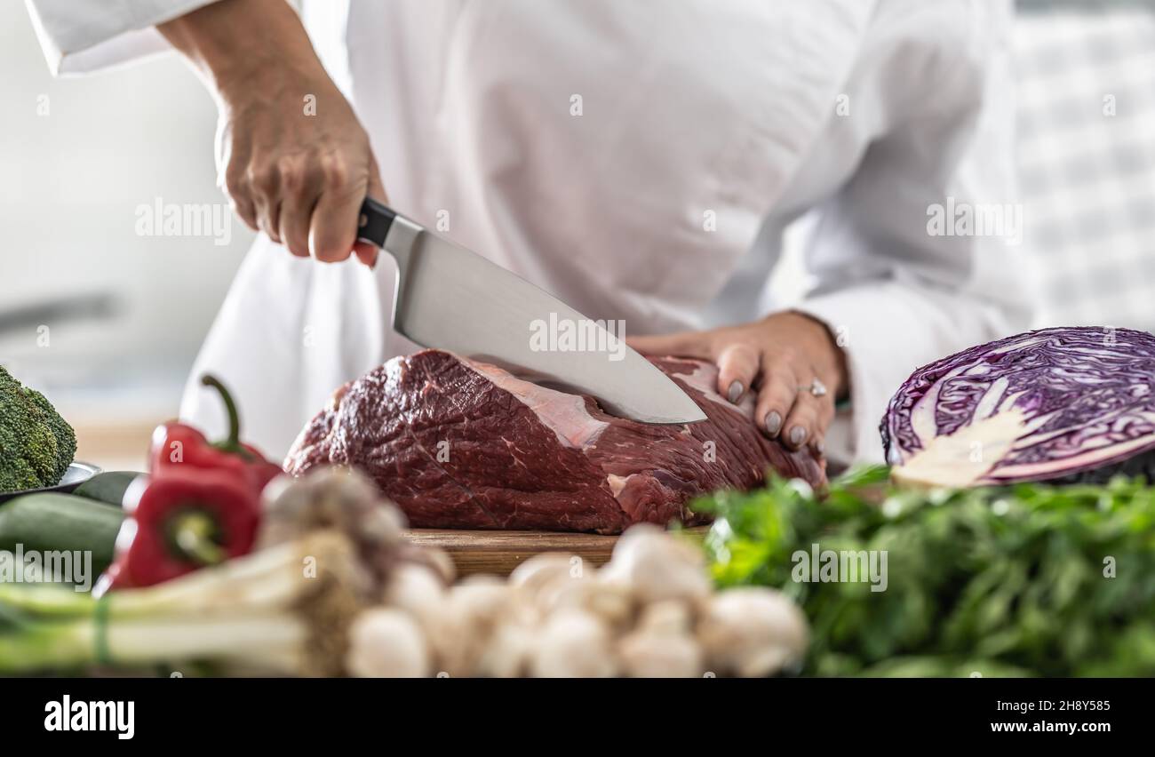 Chunk of pork meat cut with a sharp knife by professional chef with ...