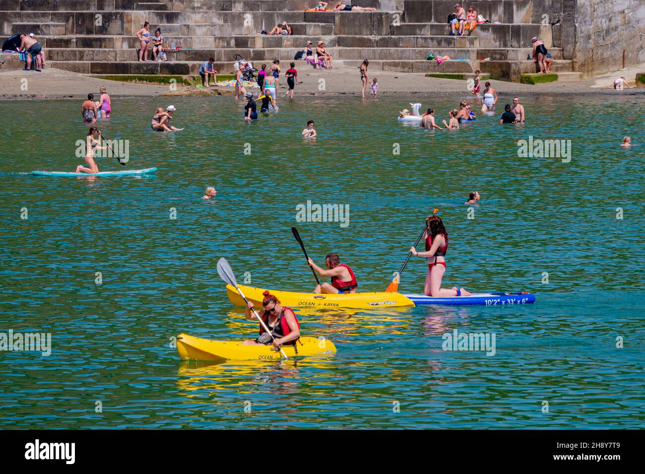 Kayakers / canoeists, paddleboarders and swimmers - Looe beach ...