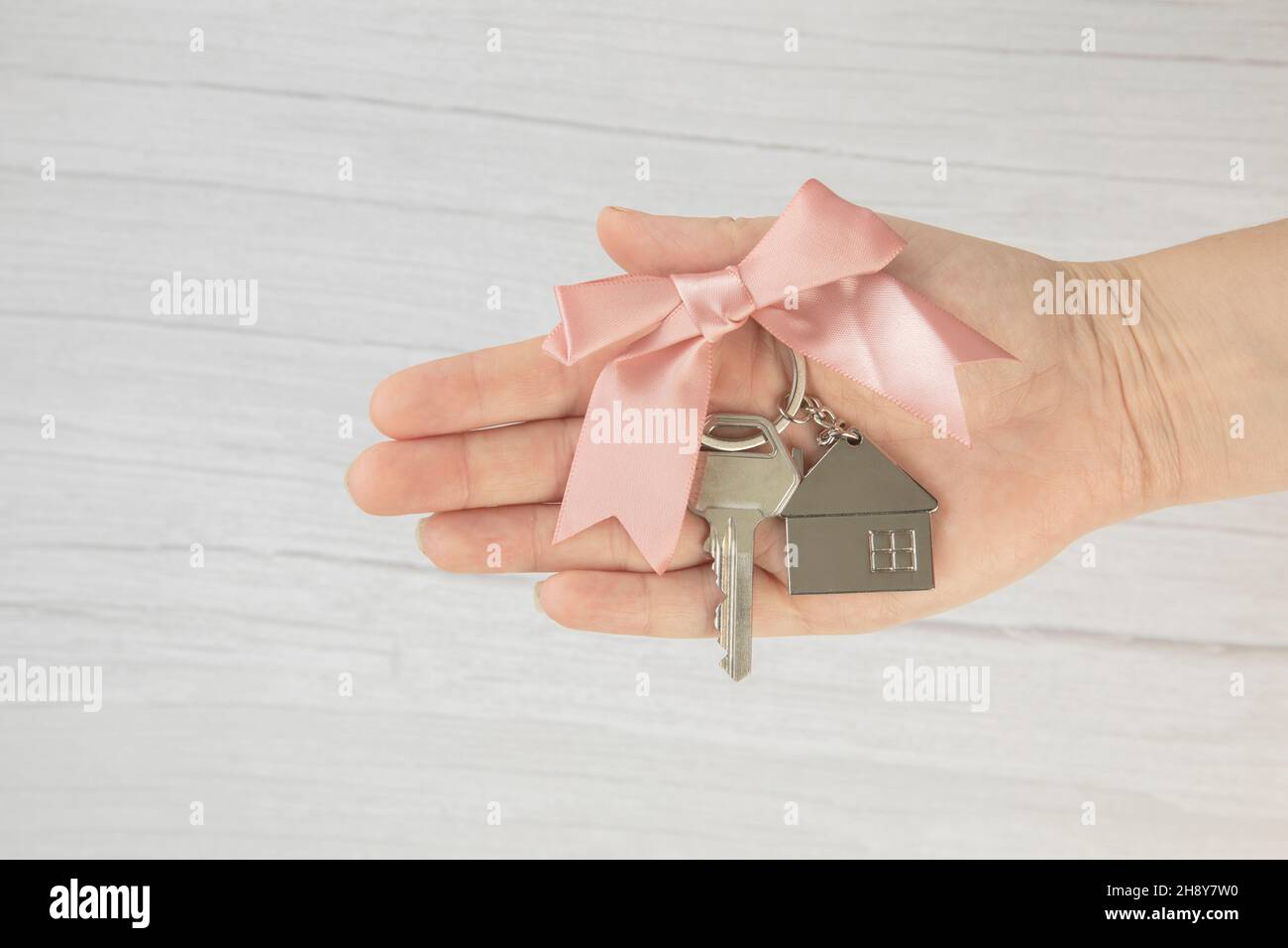 realtor female hand holding new door key to new house on white ...