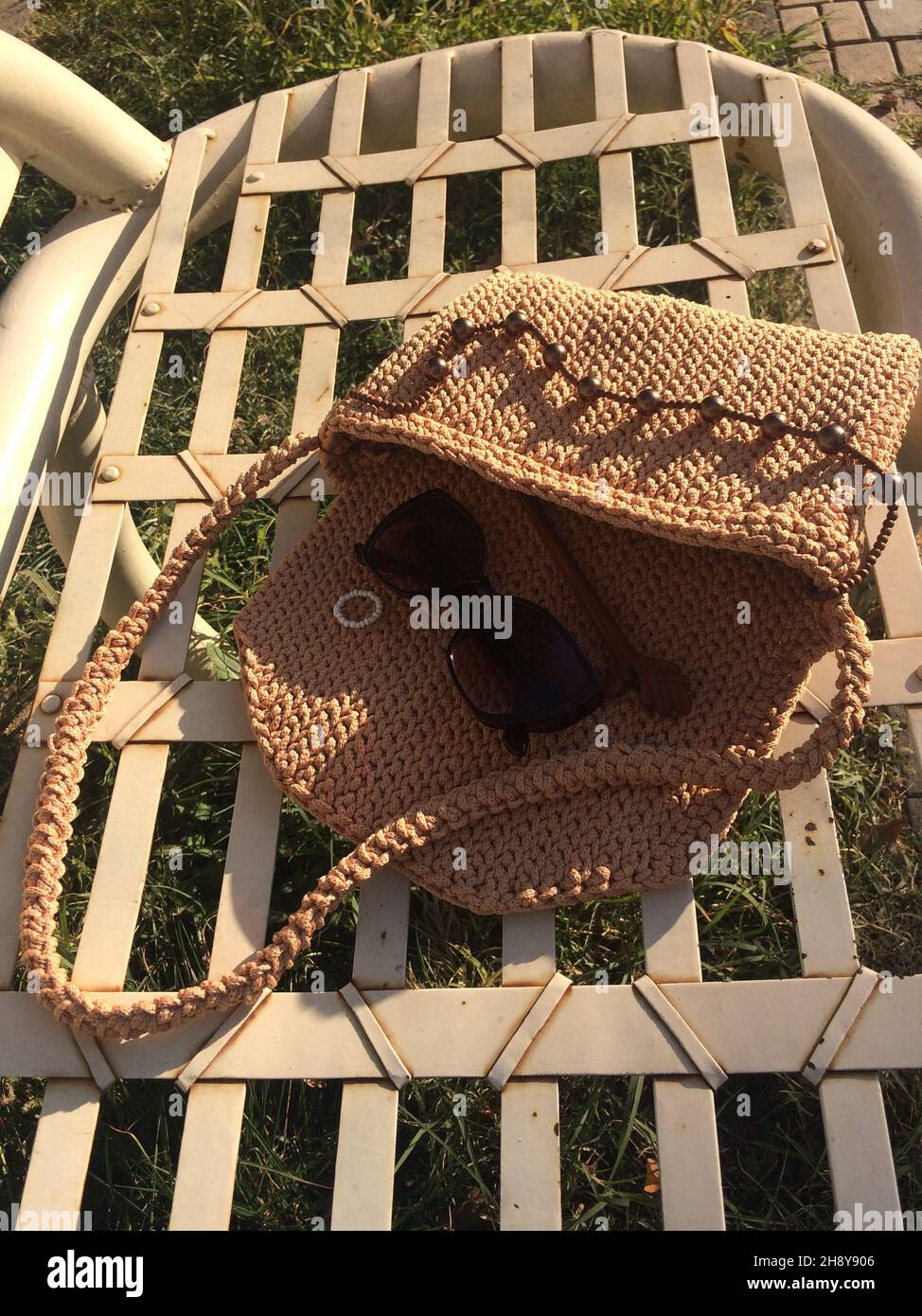 Top view shot of some sunglasses falling out of a braided bag on a ...