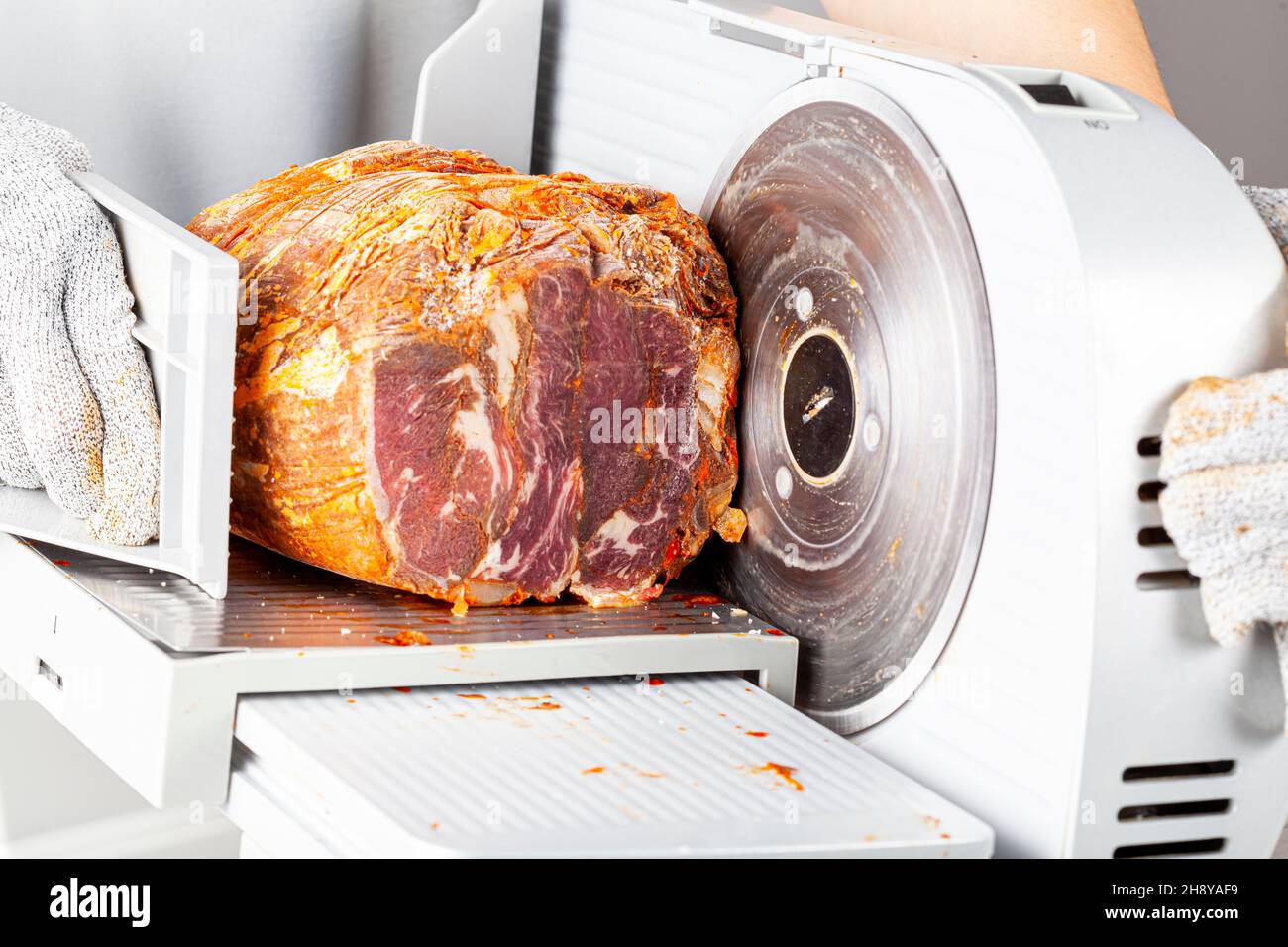 Close up isolated image showing a butcher or chef slicing a large ...
