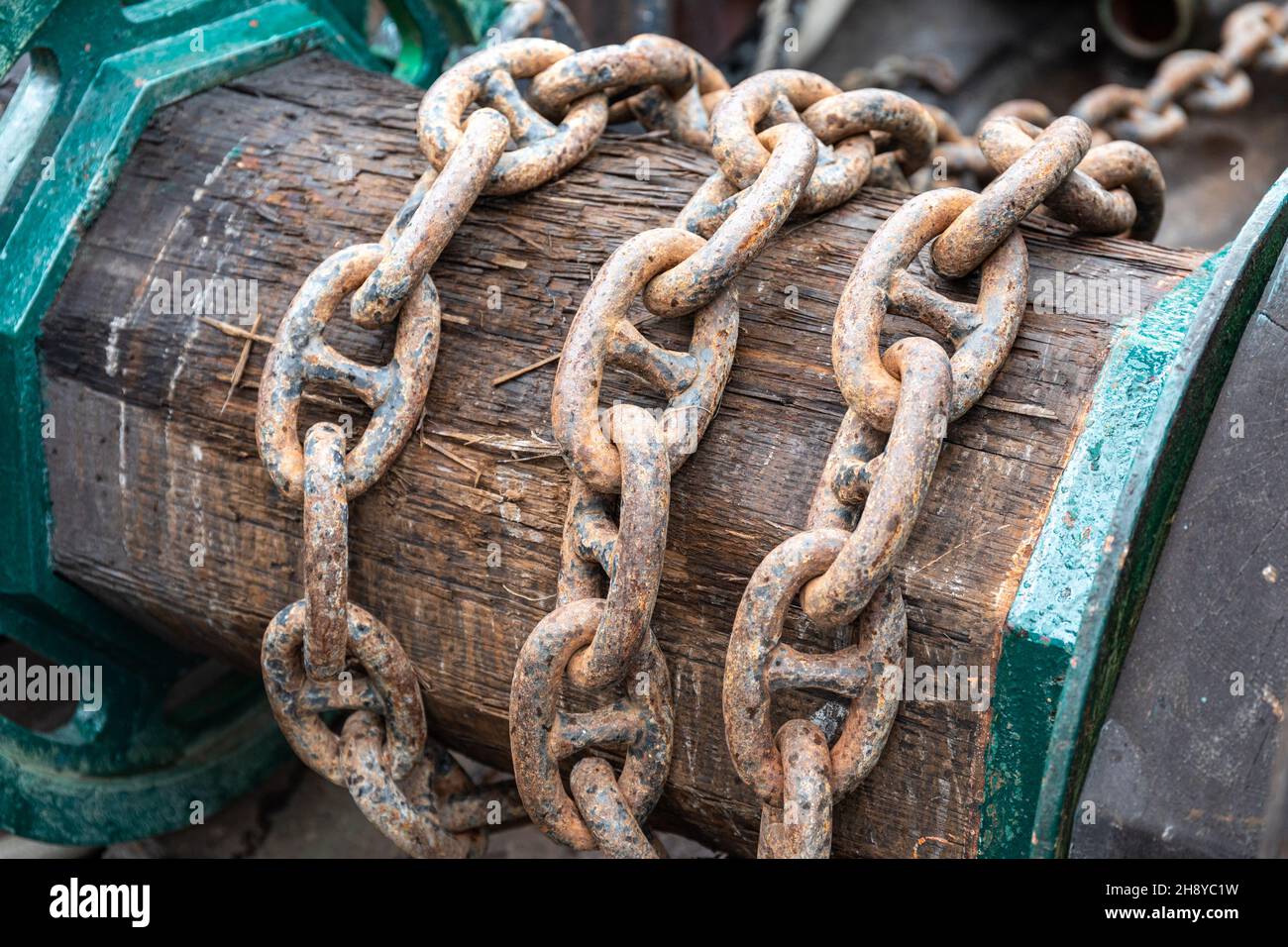Rusty anchor chain around wooden coil Stock Photo - Alamy