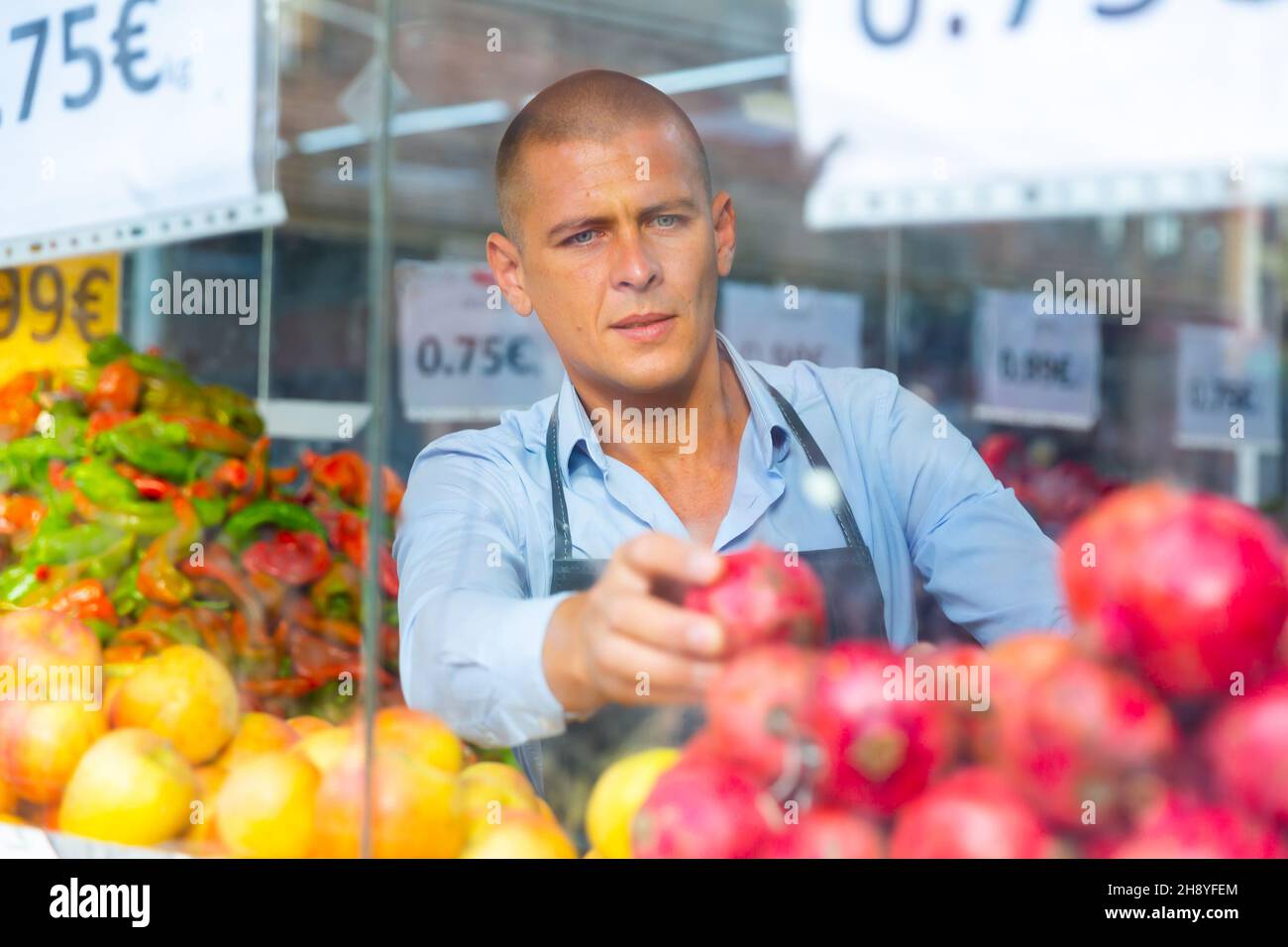 Merchandiser setting out goods in greengrocer Stock Photo - Alamy