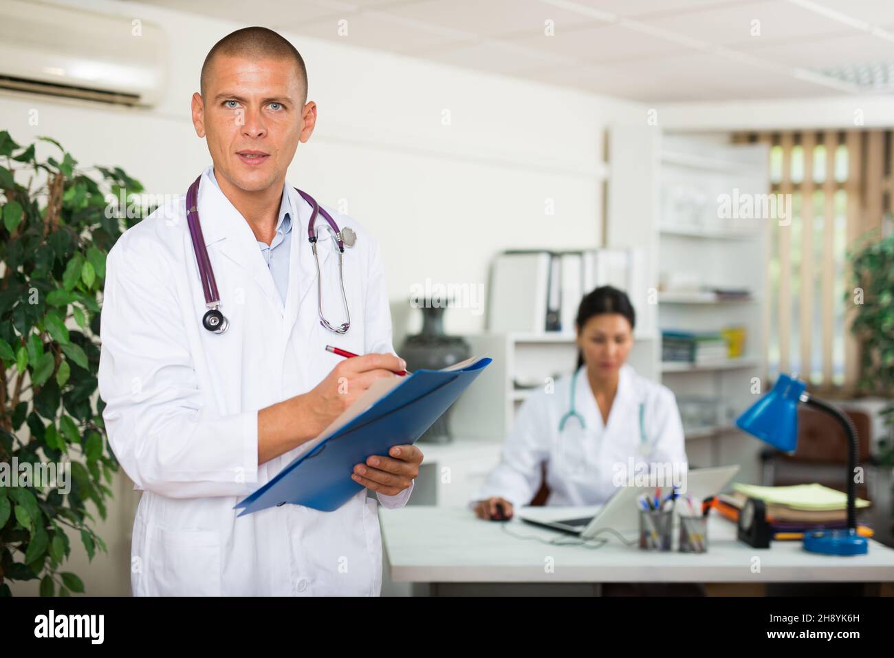 Doctor filling out medical chart hi-res stock photography and images ...