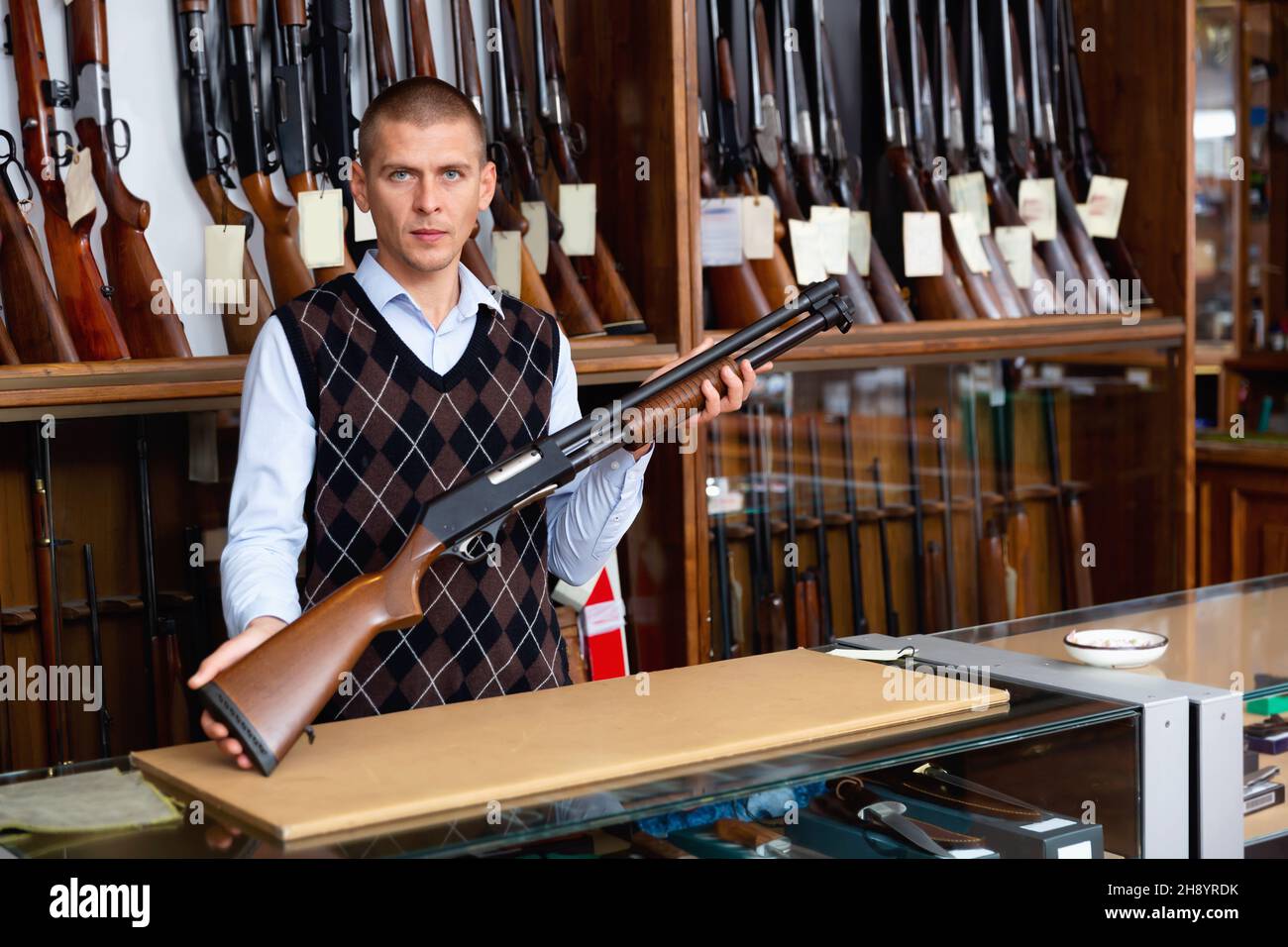 Gun shop owner demonstrating hunting air pump-action rifle Stock Photo ...