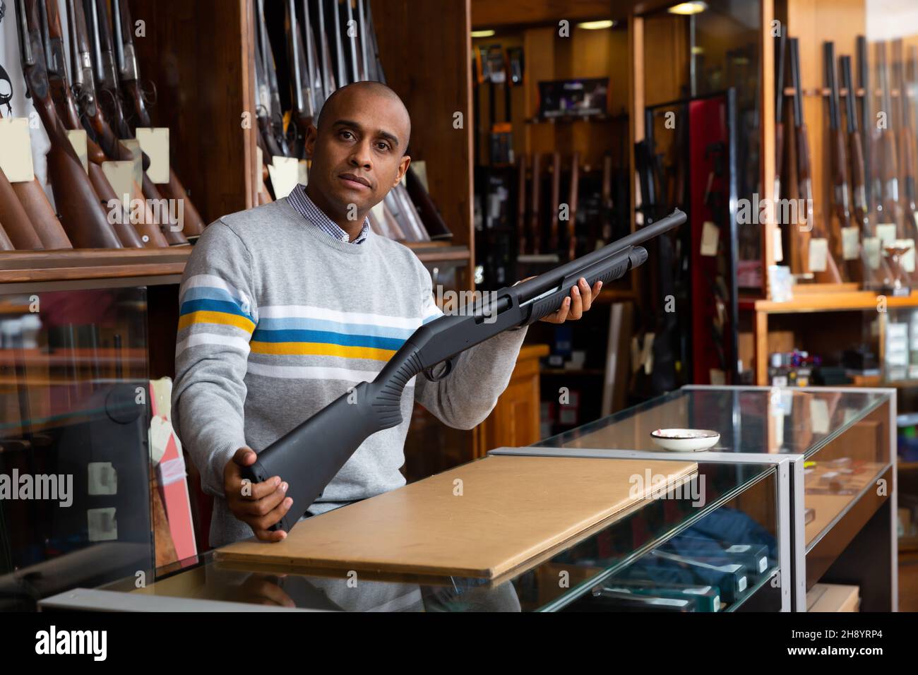 Gun shop salesman demonstrates pump action shotgun Stock Photo - Alamy