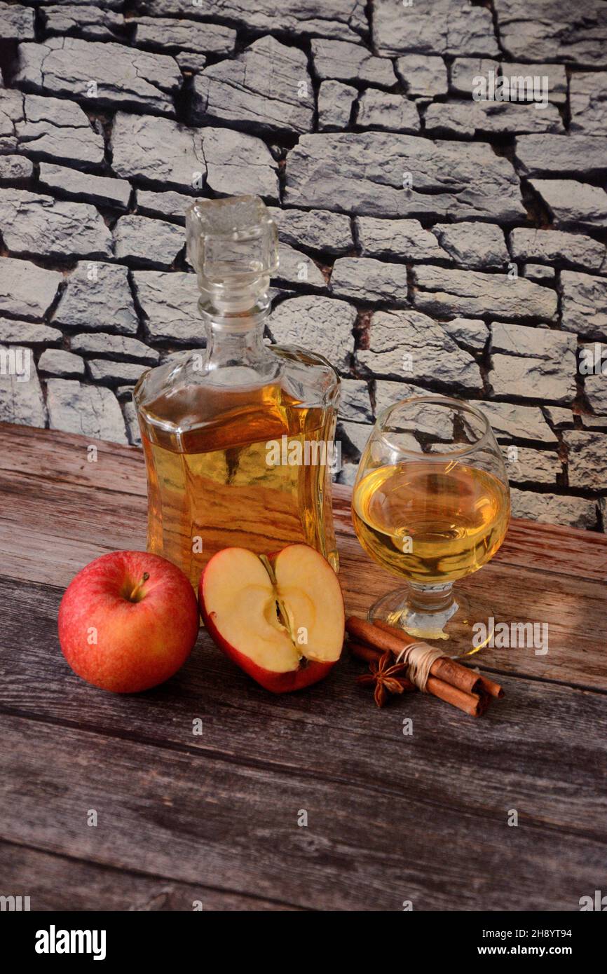 Apple calvados, spirits and ripe fruit stand on a wooden table against ...