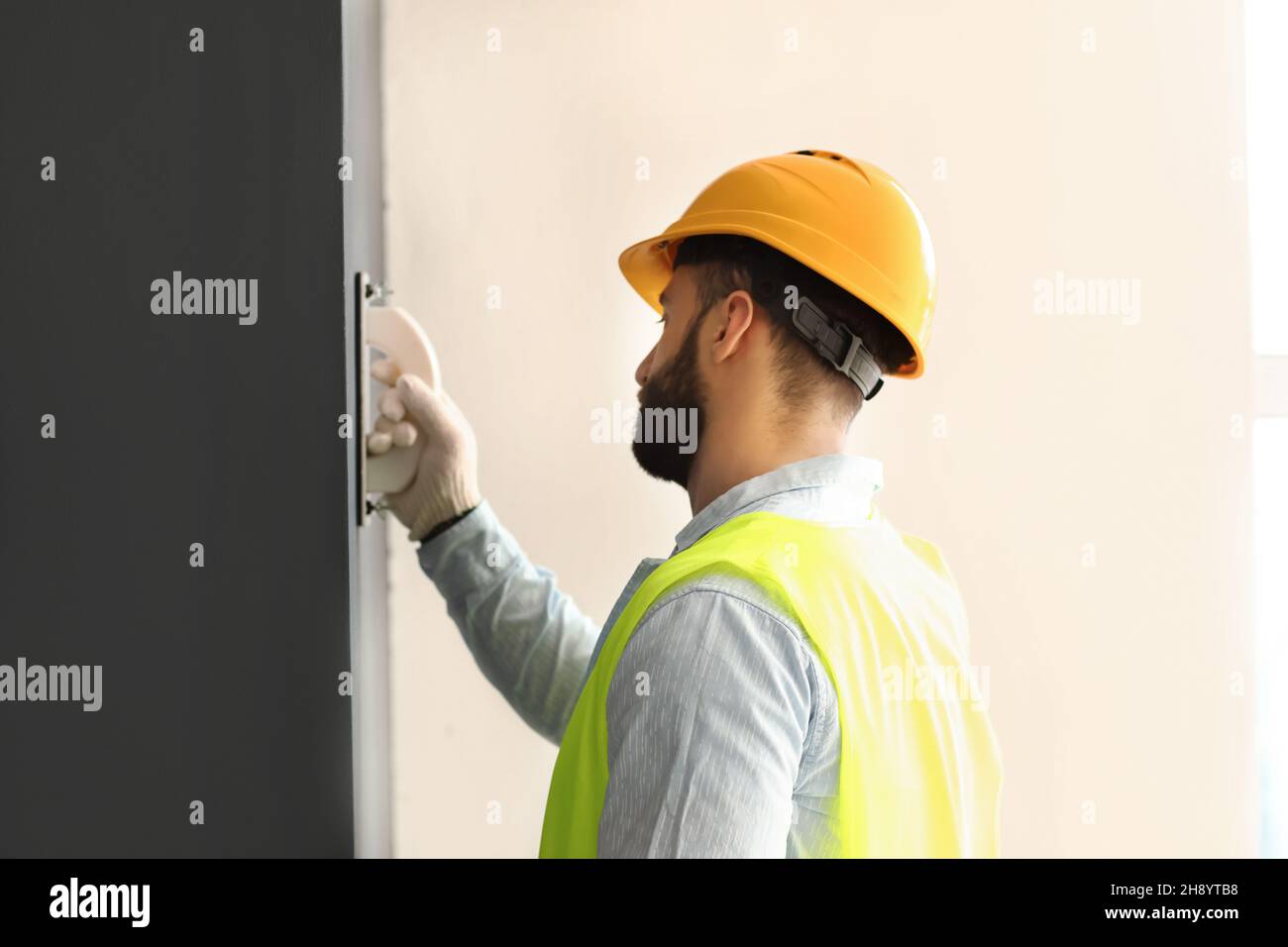 Construction worker with burnishing trowel polishing wall in room Stock ...