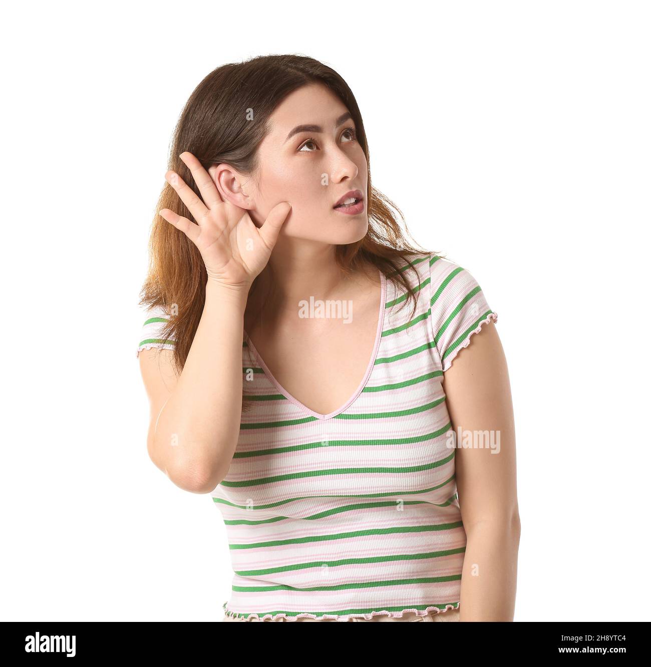 Young Asian woman trying to hear something on white background Stock ...