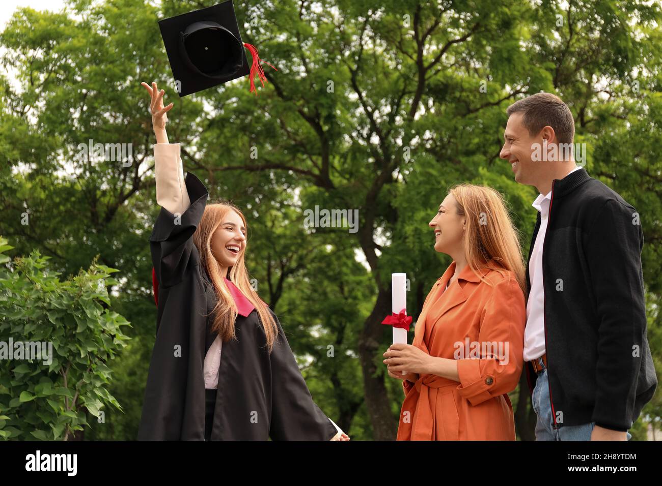 Happy young woman with her parents on graduation day Stock Photo - Alamy