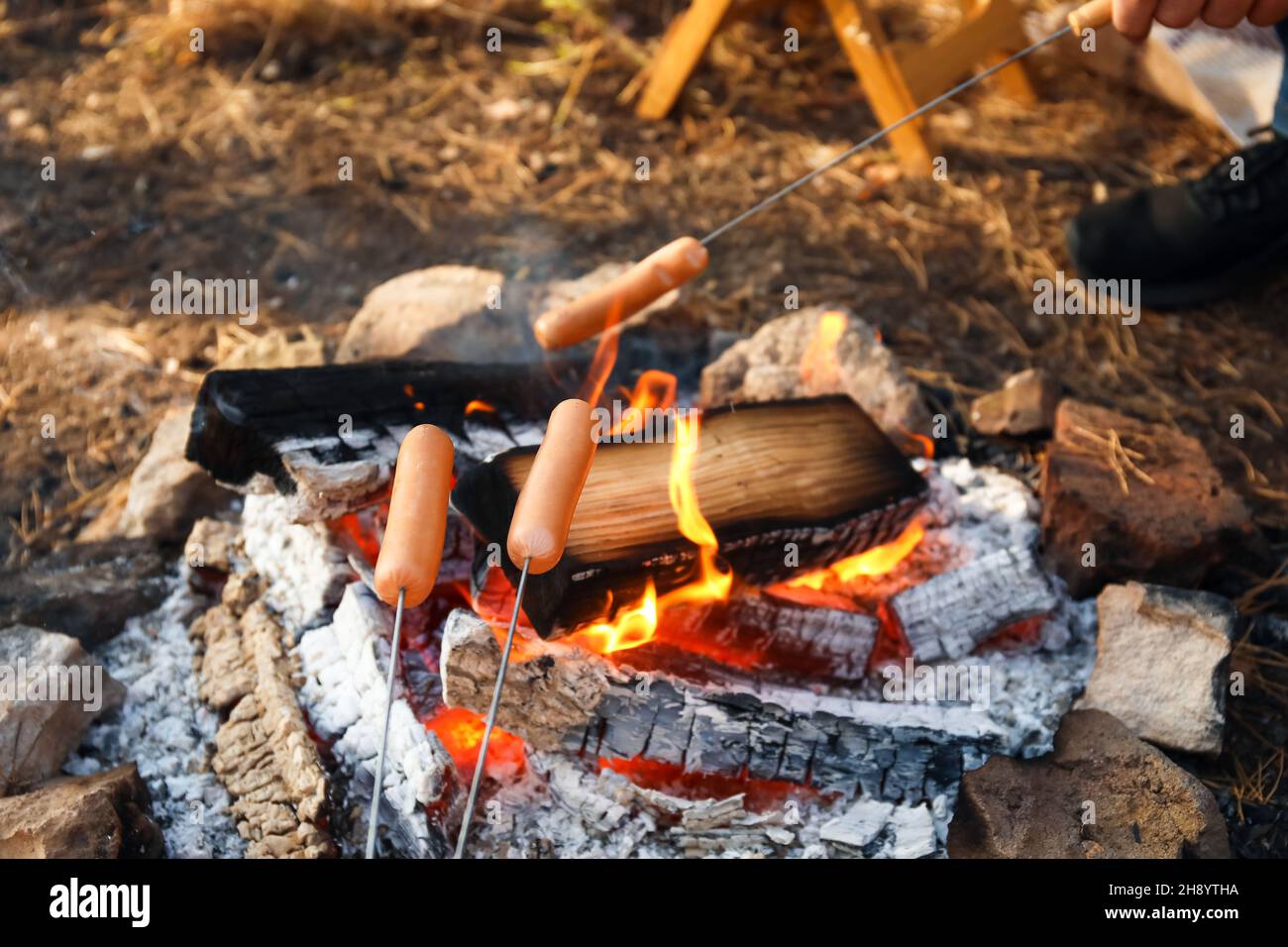 Roasting of sausages on fire outdoors Stock Photo - Alamy