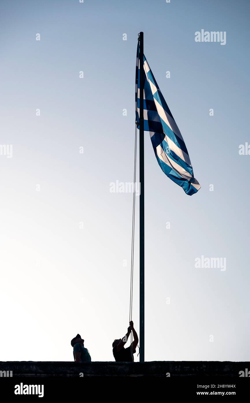 two men raising the Greek flag at the Old Fortress in Corfu Stock Photo ...
