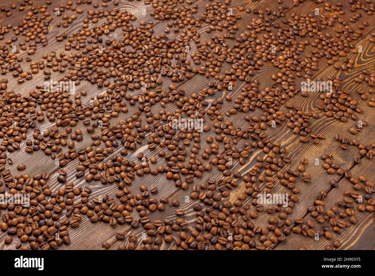roasted coffe beans spreaded over wooden board - full frame background ...