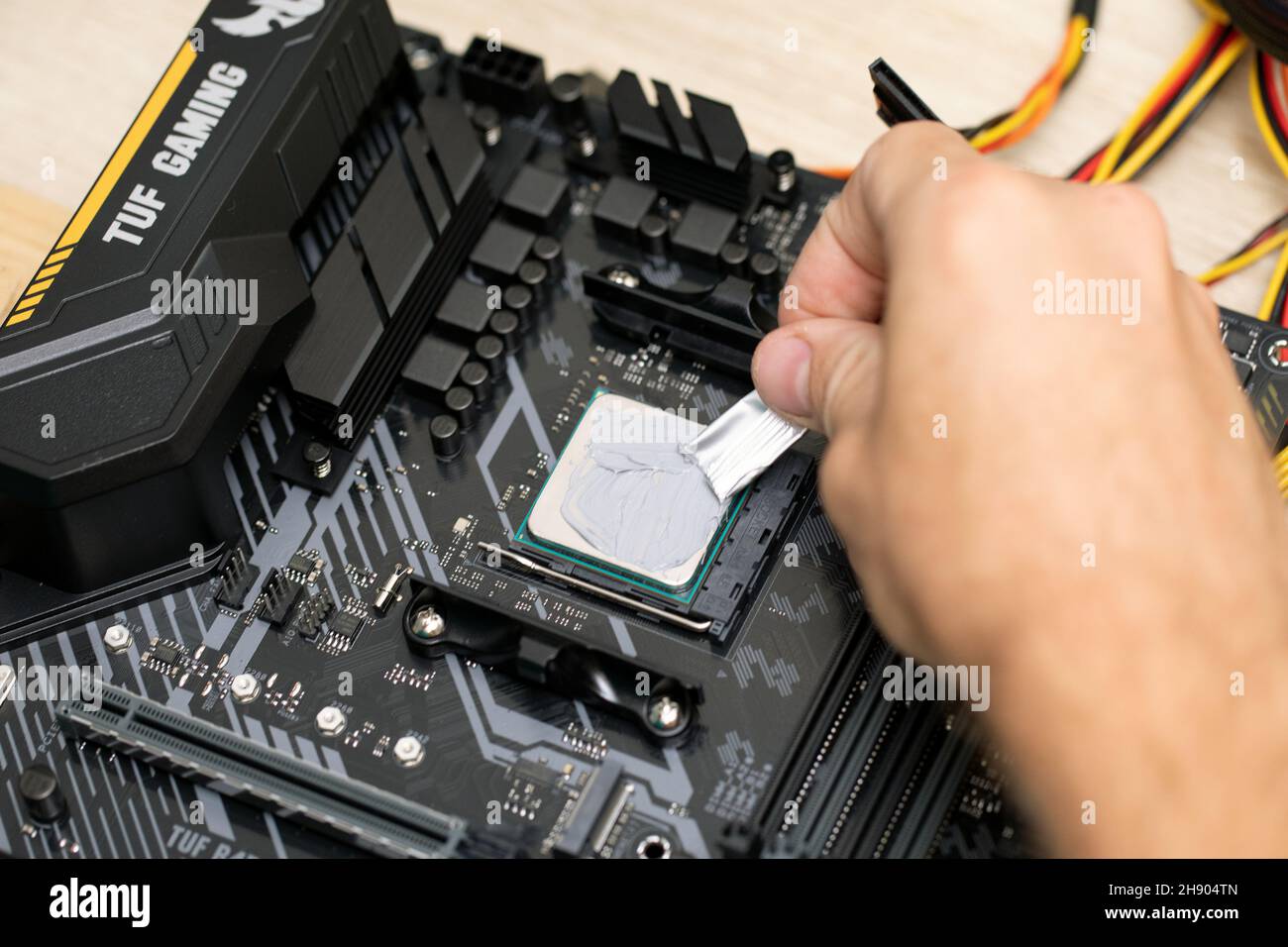 Man apply thermal paste for installing microprocessor on Tuf Gaming b450 plus motherboard ...