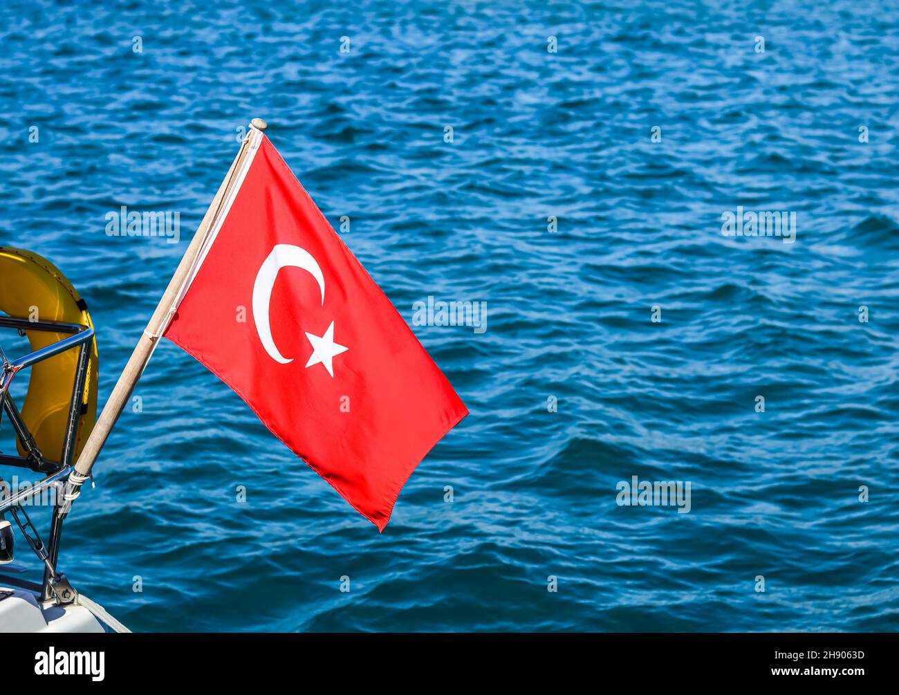 National flag of Turkey on a flagpole in the wind against a background ...