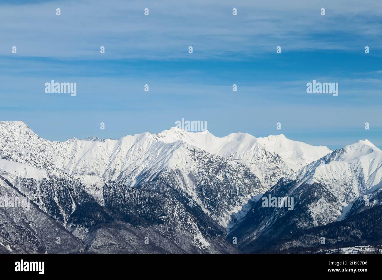 Snowy mountain ranges on the background of the blue sky with clouds ...