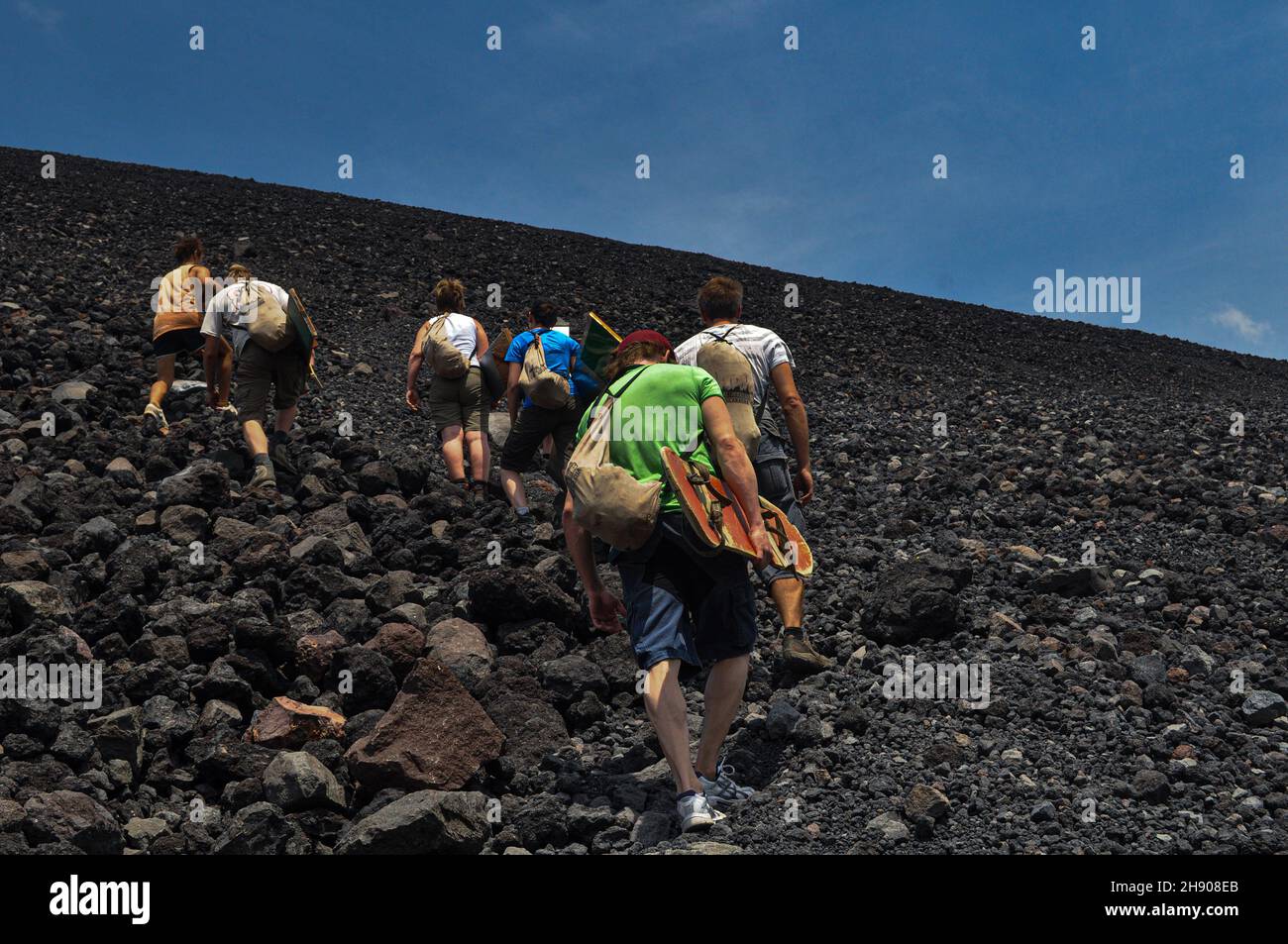 Foreign tourists climb the slopes of the Cerro Negro volcano to ...