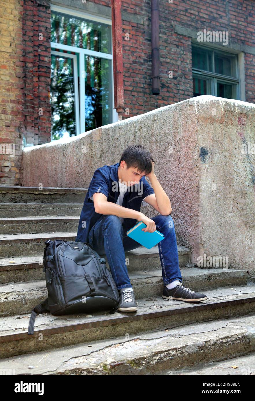 Sad Student with the Book on the landing steps of the Old House Stock ...