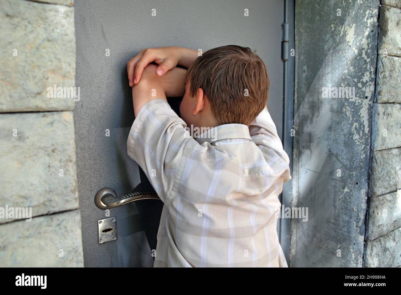 Sad Kid in front of Closed Door Stock Photo - Alamy