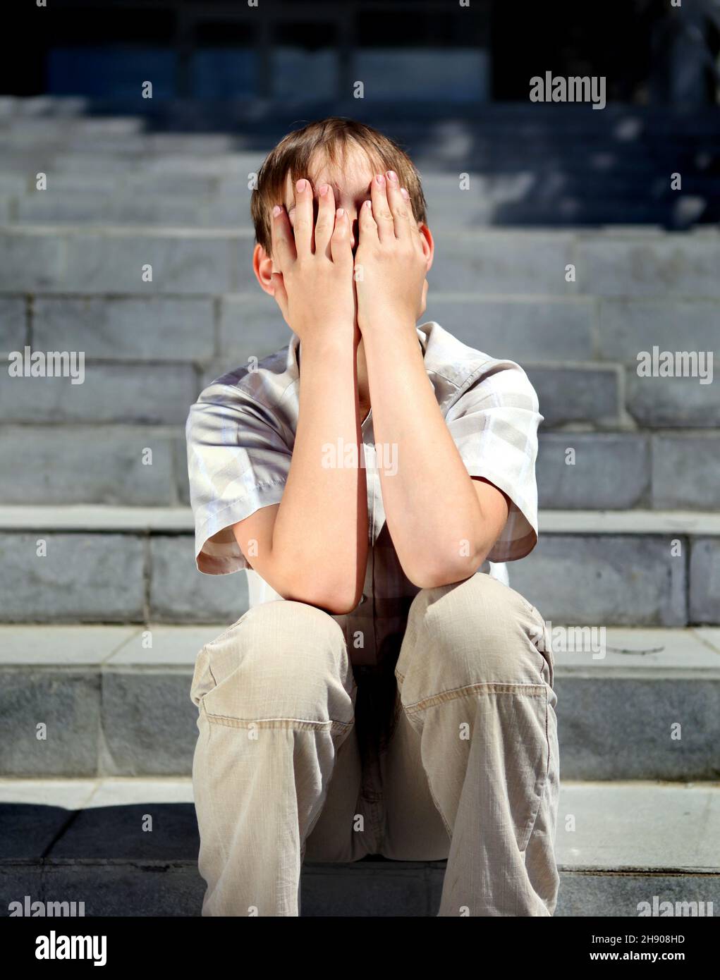 Sad and Troubled Kid sit on the Landing Steps outdoor Stock Photo - Alamy