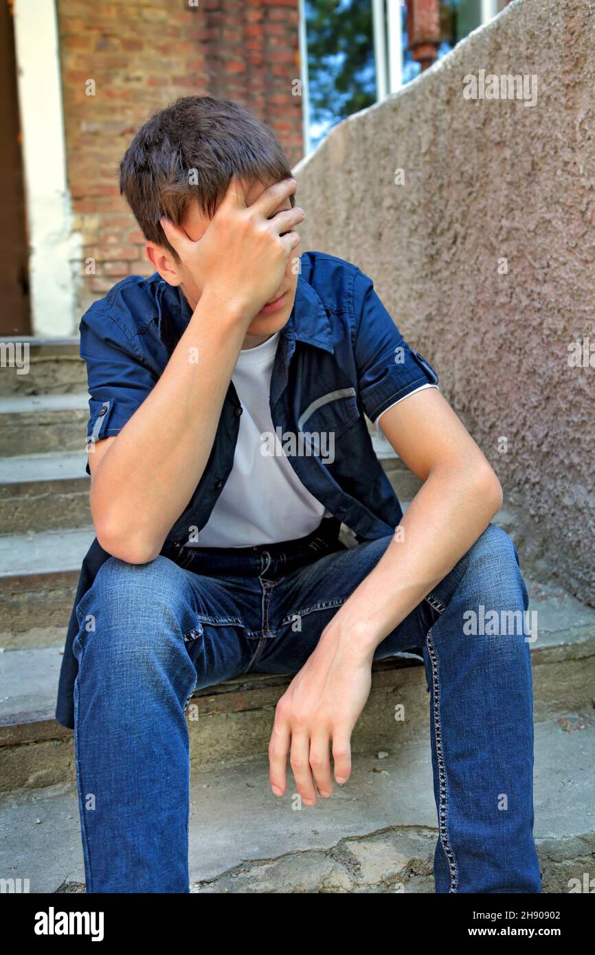 Sad Young Man on the landing Steps of the Old House Stock Photo - Alamy