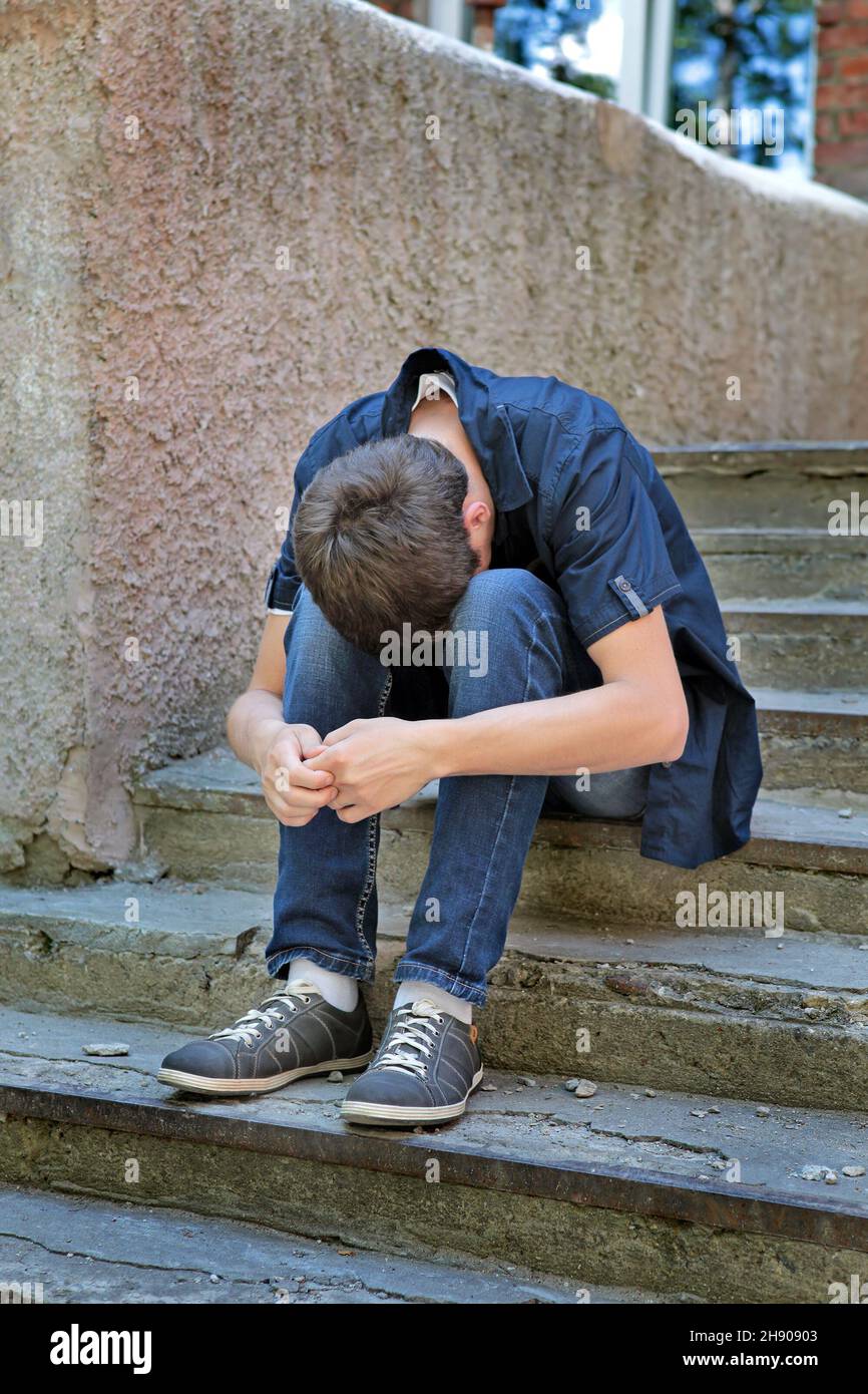 Sad Young Man on the landing Steps of the Old House Stock Photo - Alamy