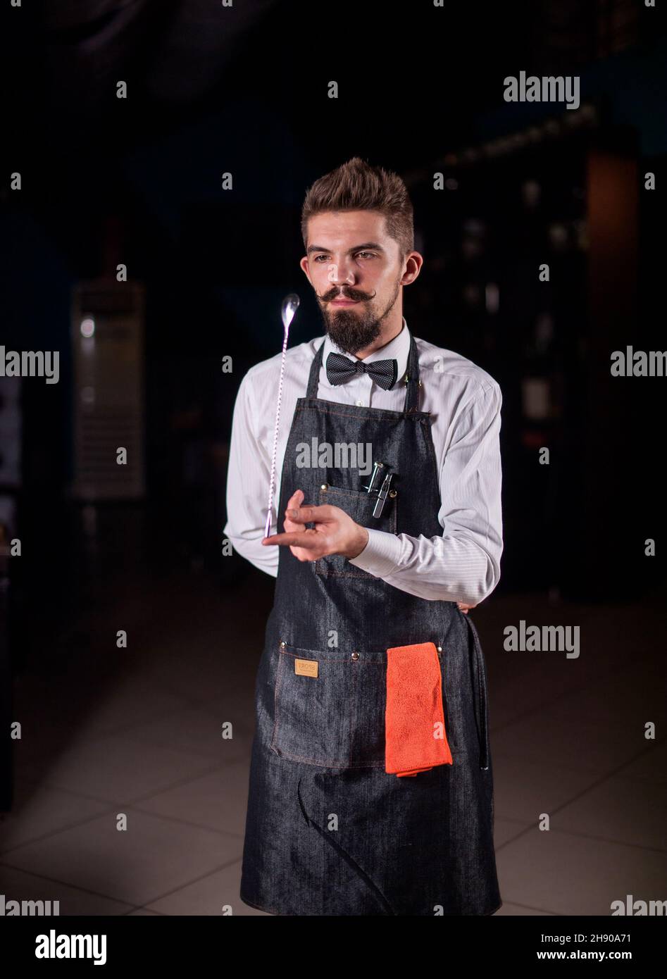 Professional friendly waiter helpfully serves dish in the restaurant ...