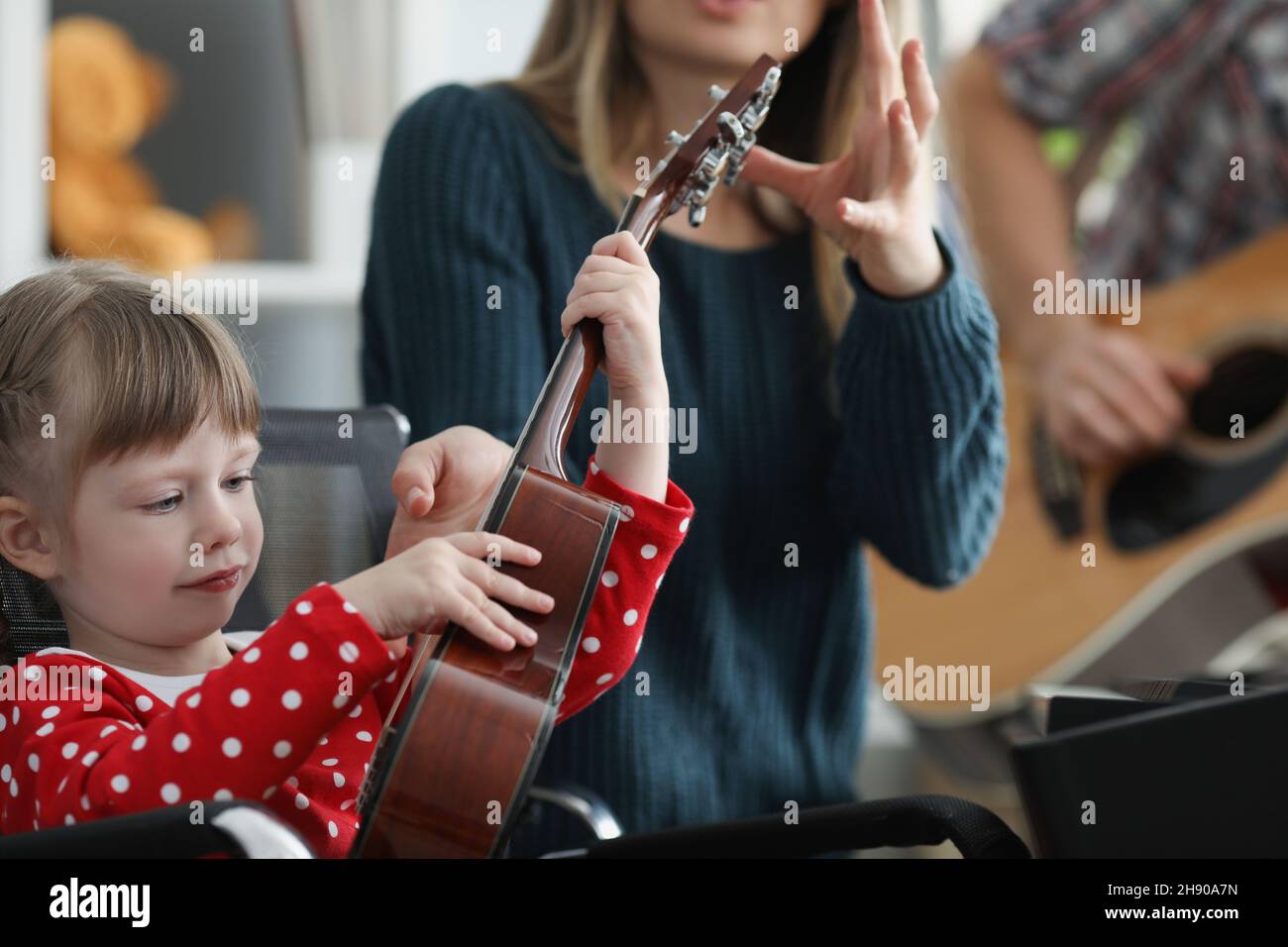 Mother take musical instrument from daughter hands to show how to play ...