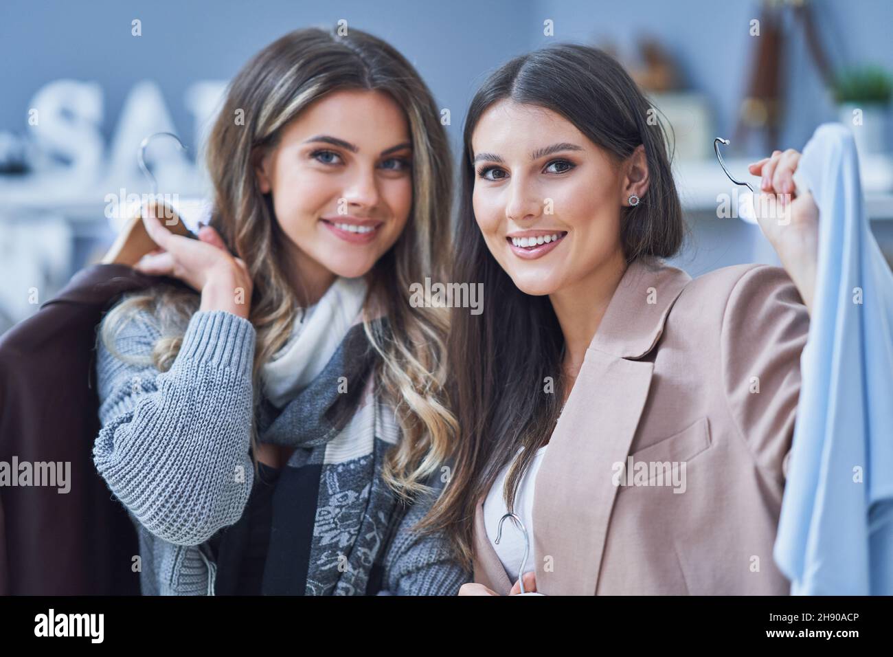 Two happy girls in clothes store during shopping Stock Photo - Alamy