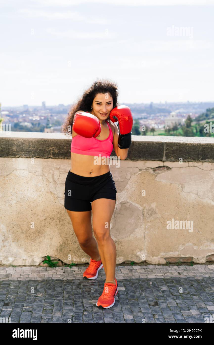 Photo of strong fitness woman boxer in gloves posing outdoors Stock ...