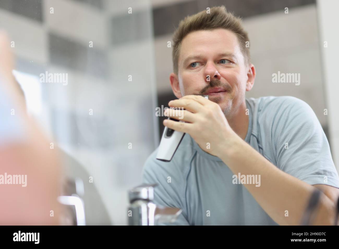 Middle aged man shaving beard with electronic machine Stock Photo - Alamy