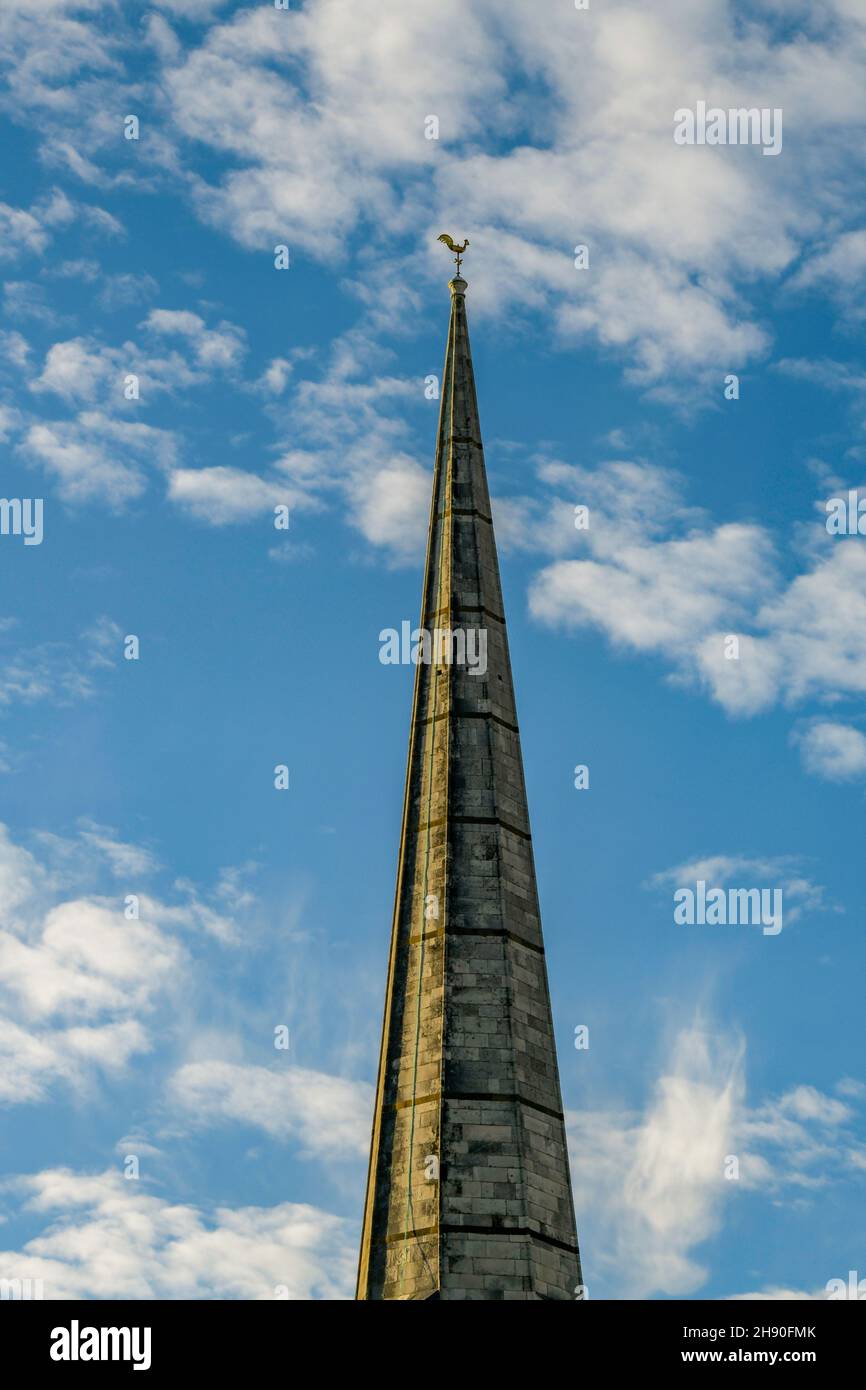 tall church steeple against blue sky with clouds, long church tower on ...