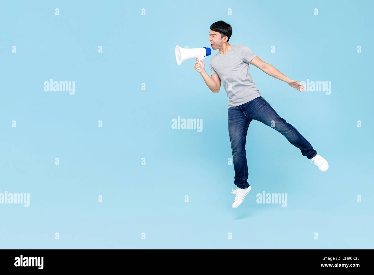 Unhappy announcement portrait of jumping young angry Asian man yelling ...