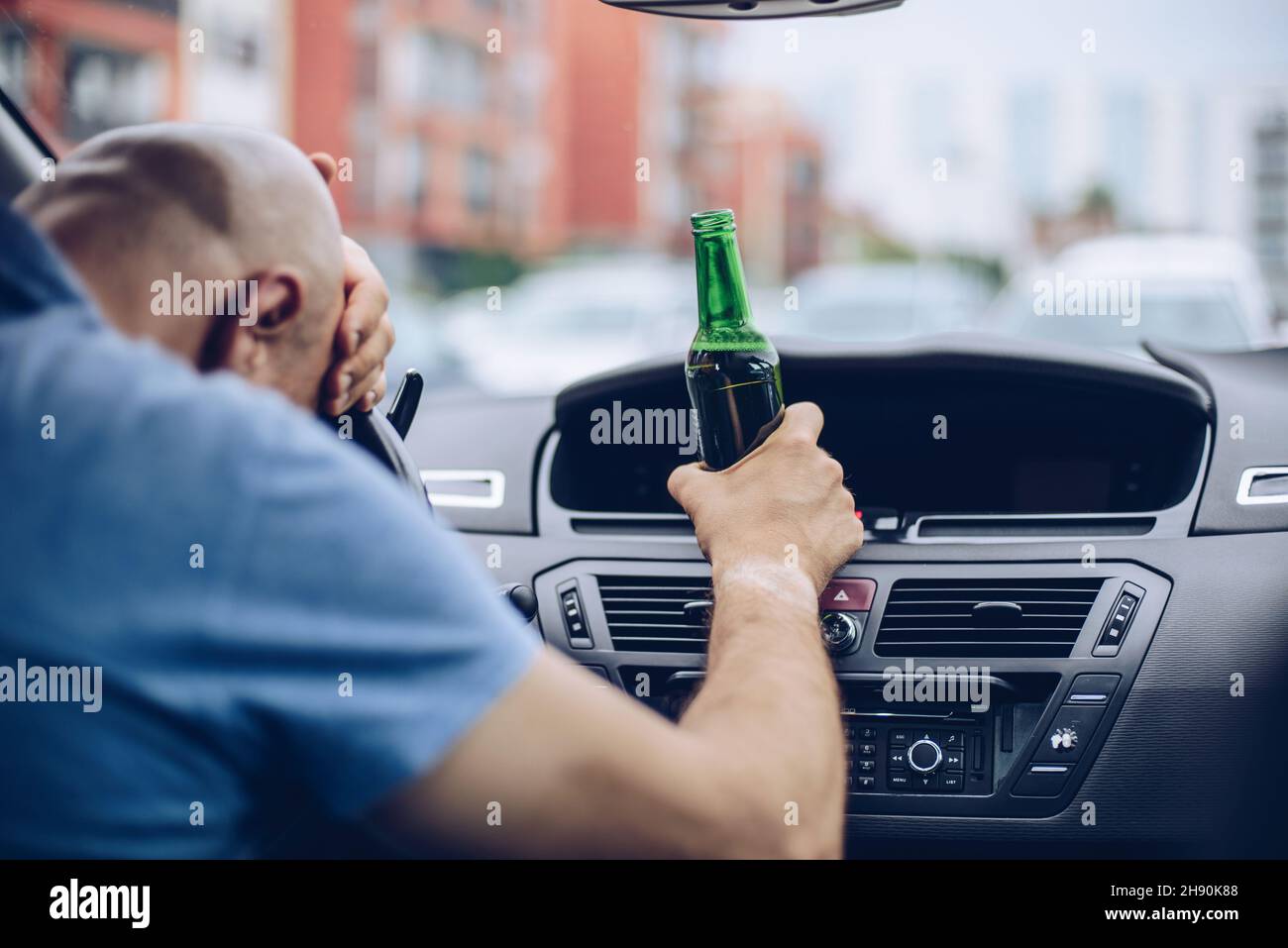 Man drives a car with a bottle of beer behind the wheel of a car Stock ...