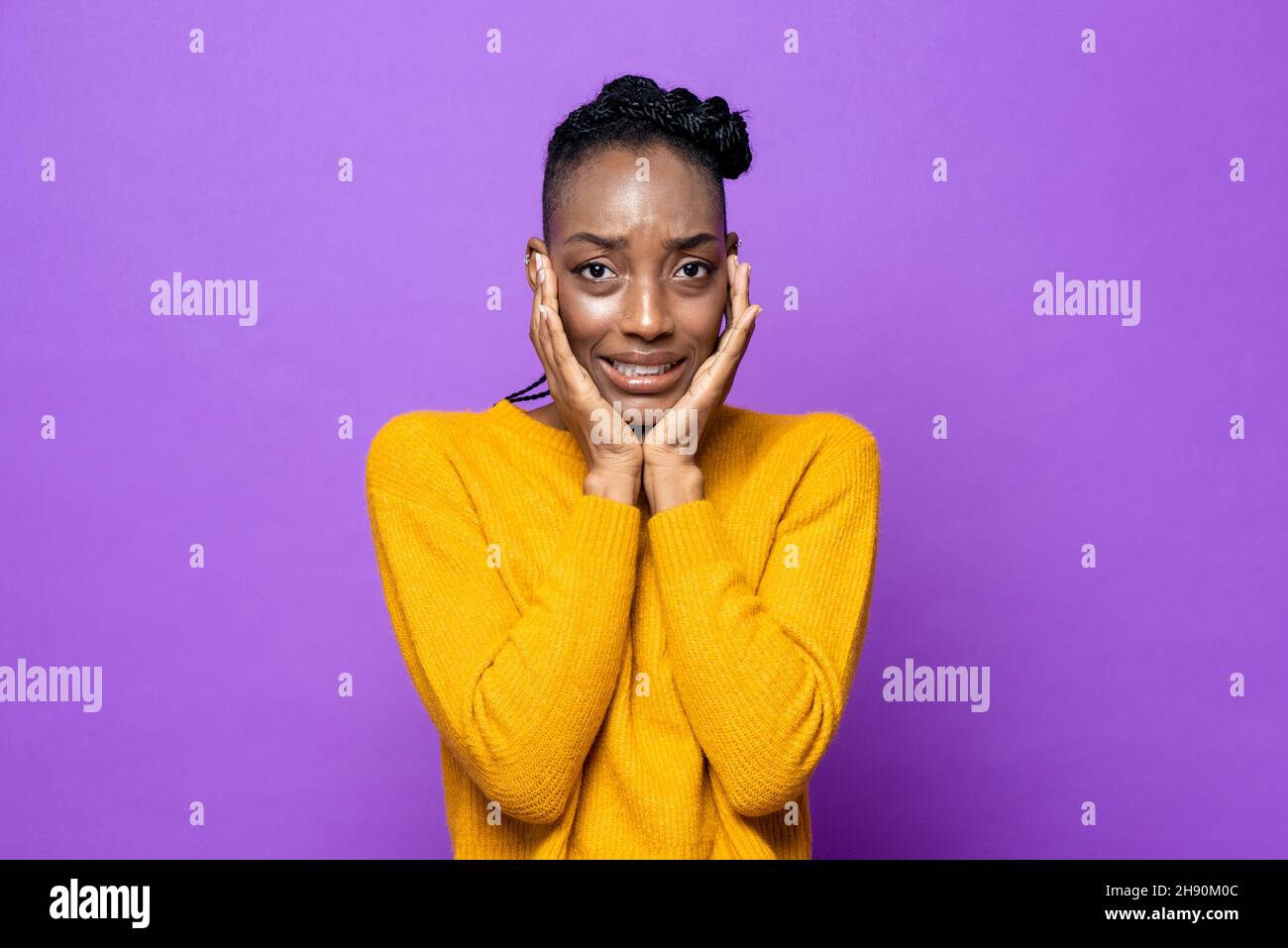 Young African-American woman feeling fear and frightened with hands on ...