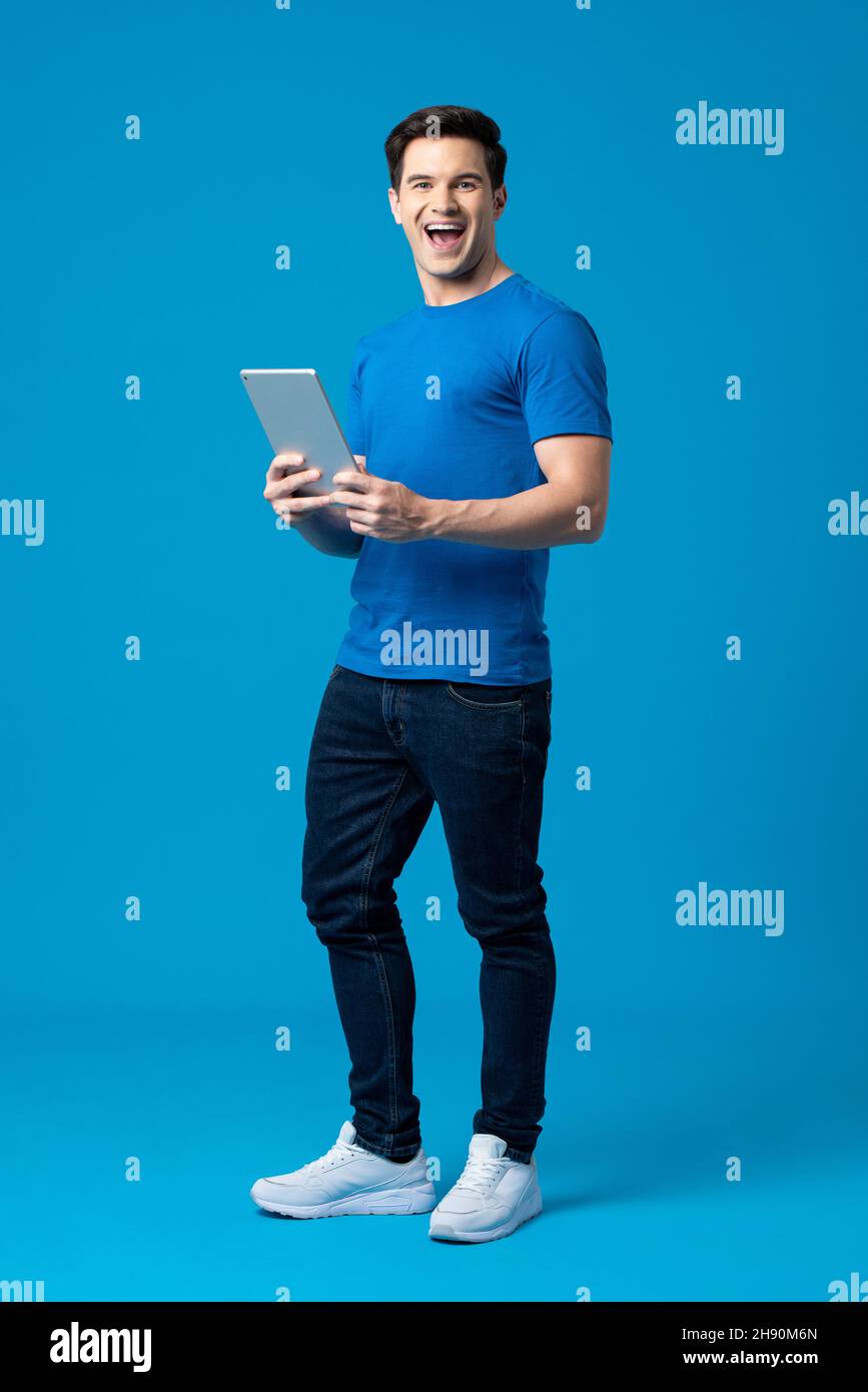 Surprise young handsome Caucasian man smiling and holding laptop ...