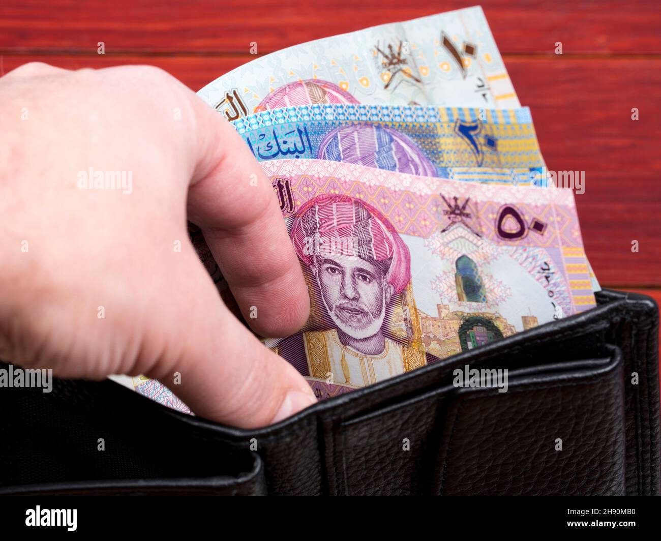 Omani money - rial in the black wallet Stock Photo - Alamy