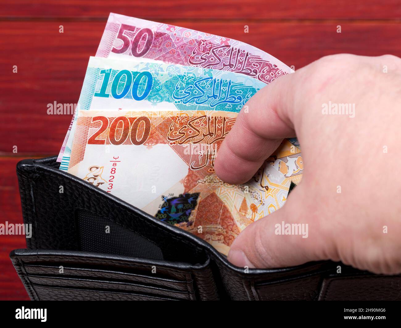 Qatari money - Riyal in the black wallet Stock Photo - Alamy