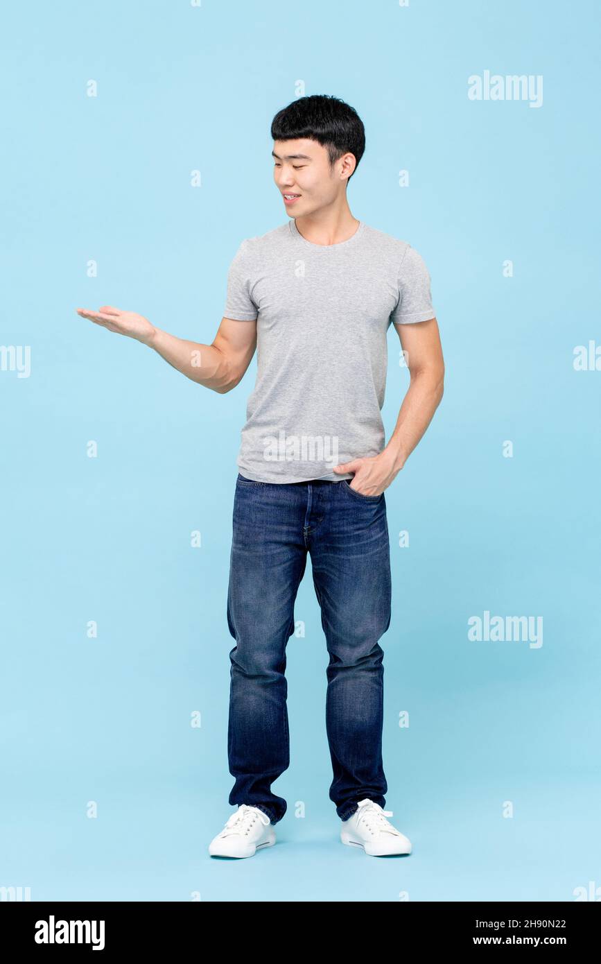 Young Asian man looking at his empty opening hand in isolated blue ...