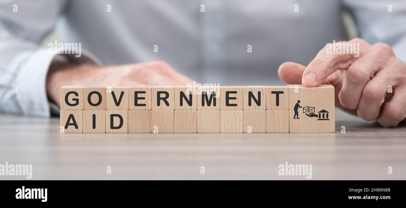 Wooden blocks with symbol of government aid concept Stock Photo - Alamy