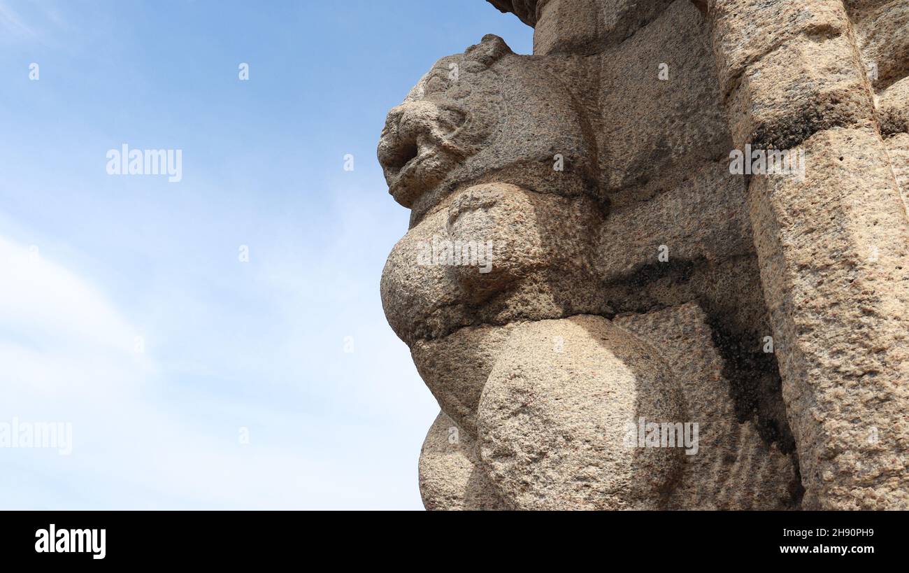 Statues carved into the rock wall. Against the backdrop of blue sky ...
