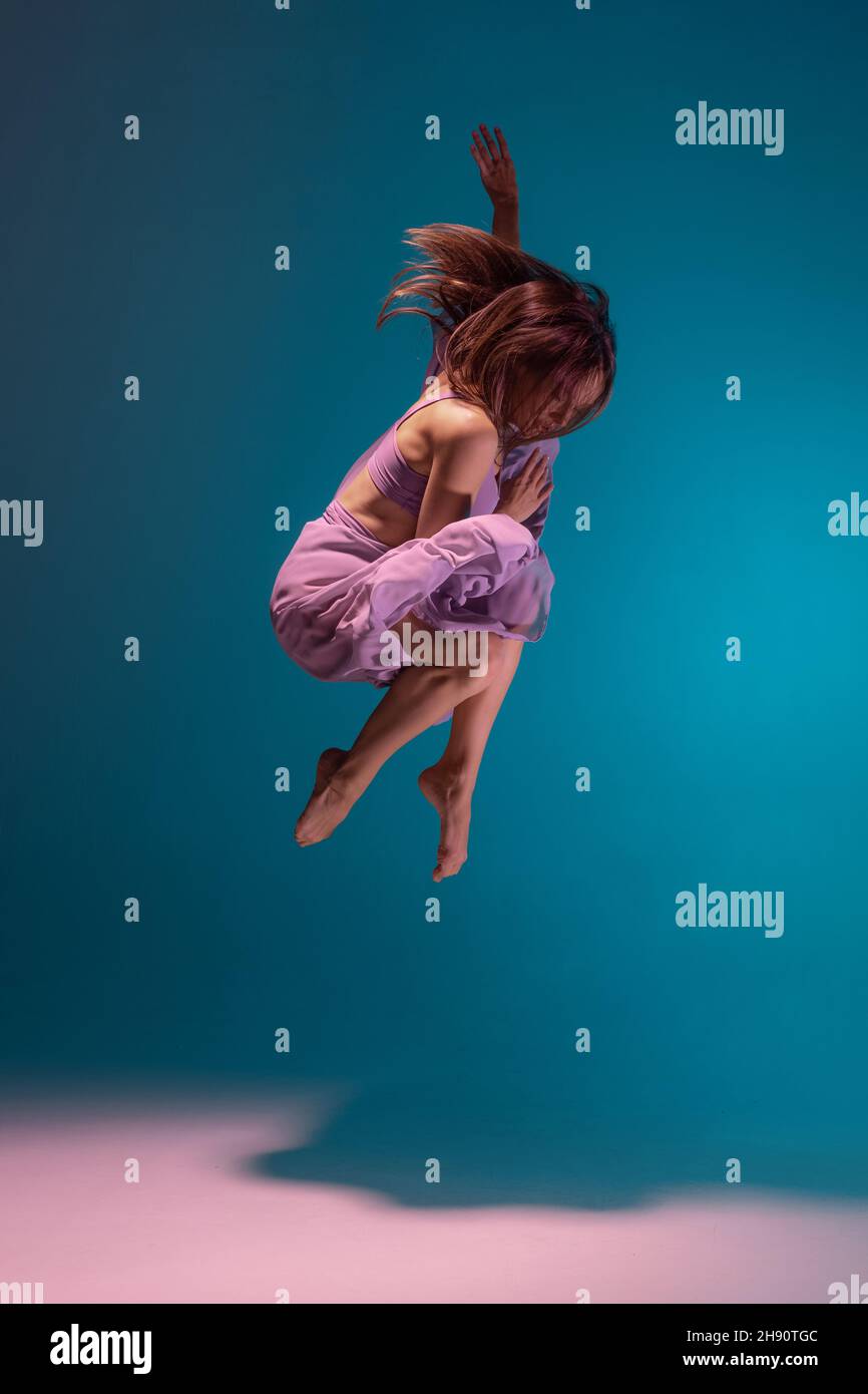 One young flexible contemp dancer in lilac dress dancing isolated on ...