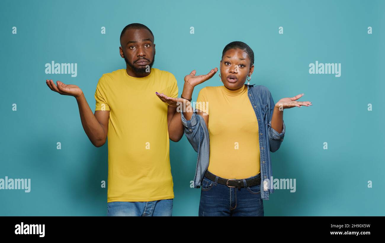 Uncertain people raising shoulders and not knowing to answer question ...