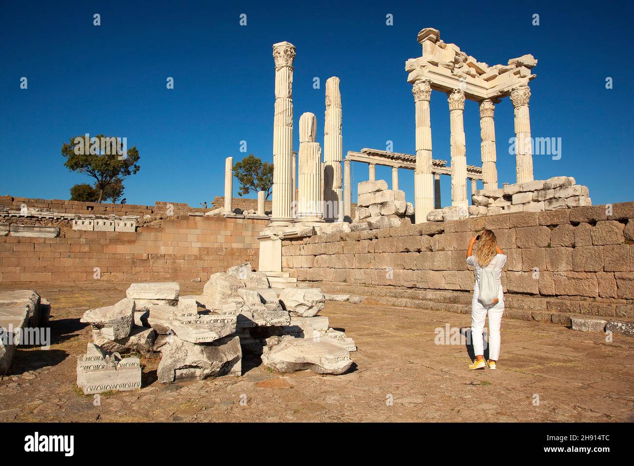 Tourist woman taking photos of the marble columns and rests of The ...