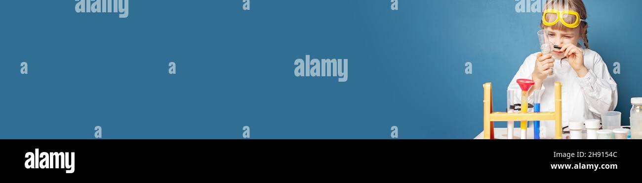 Little scientist child wearing safety goggles on blue background with ...